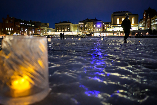 Participants walk a path lit by frozen luminaries on Lake Mendota near ...